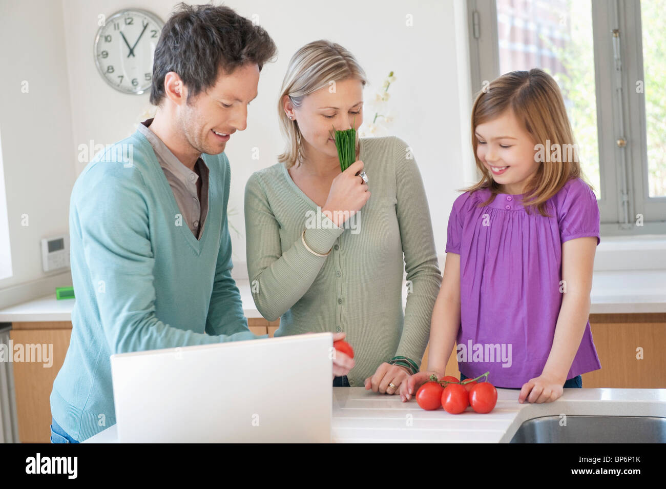 Family cooking with the recipe on a laptop Stock Photo - Alamy
