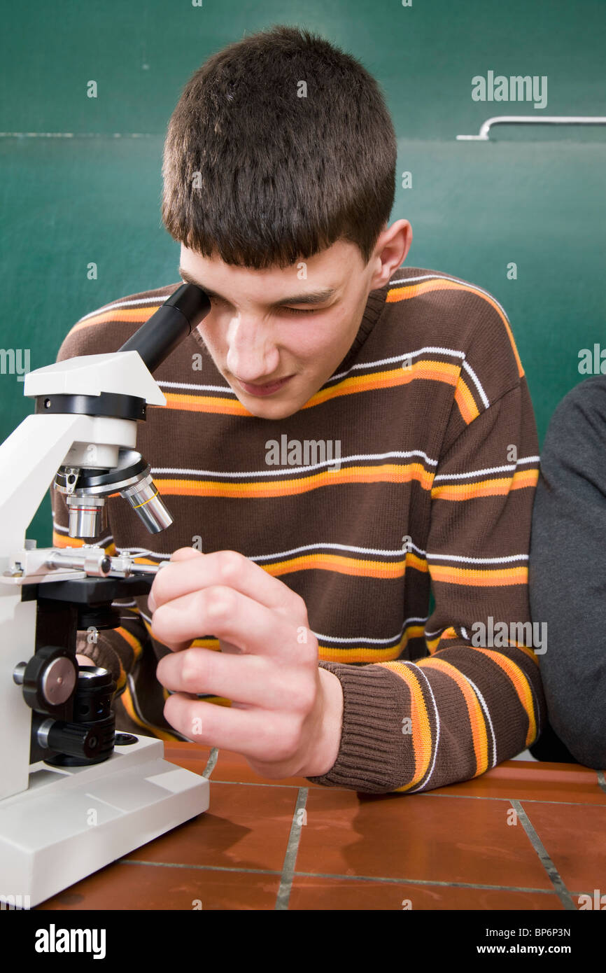 A student looking through a microscope in biology class Stock Photo - Alamy