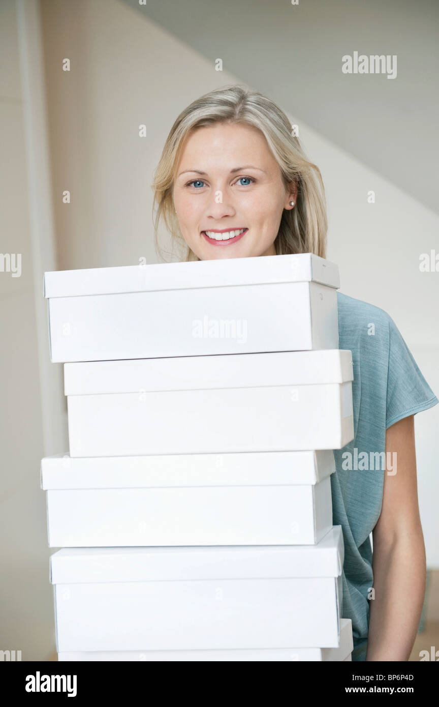 Portrait of a woman carrying shoe boxes Stock Photo - Alamy