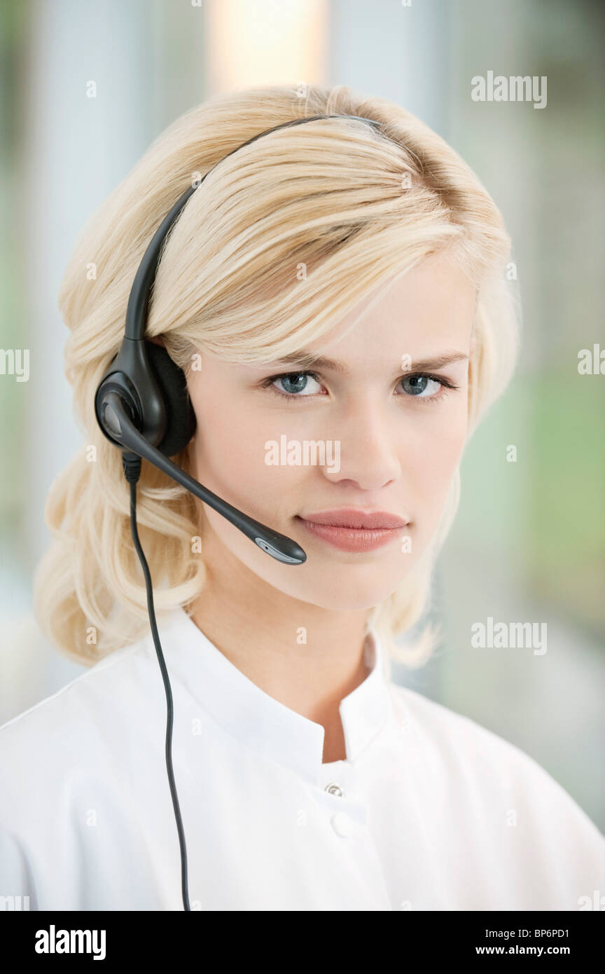 Portrait of a female customer service representative wearing a headset ...