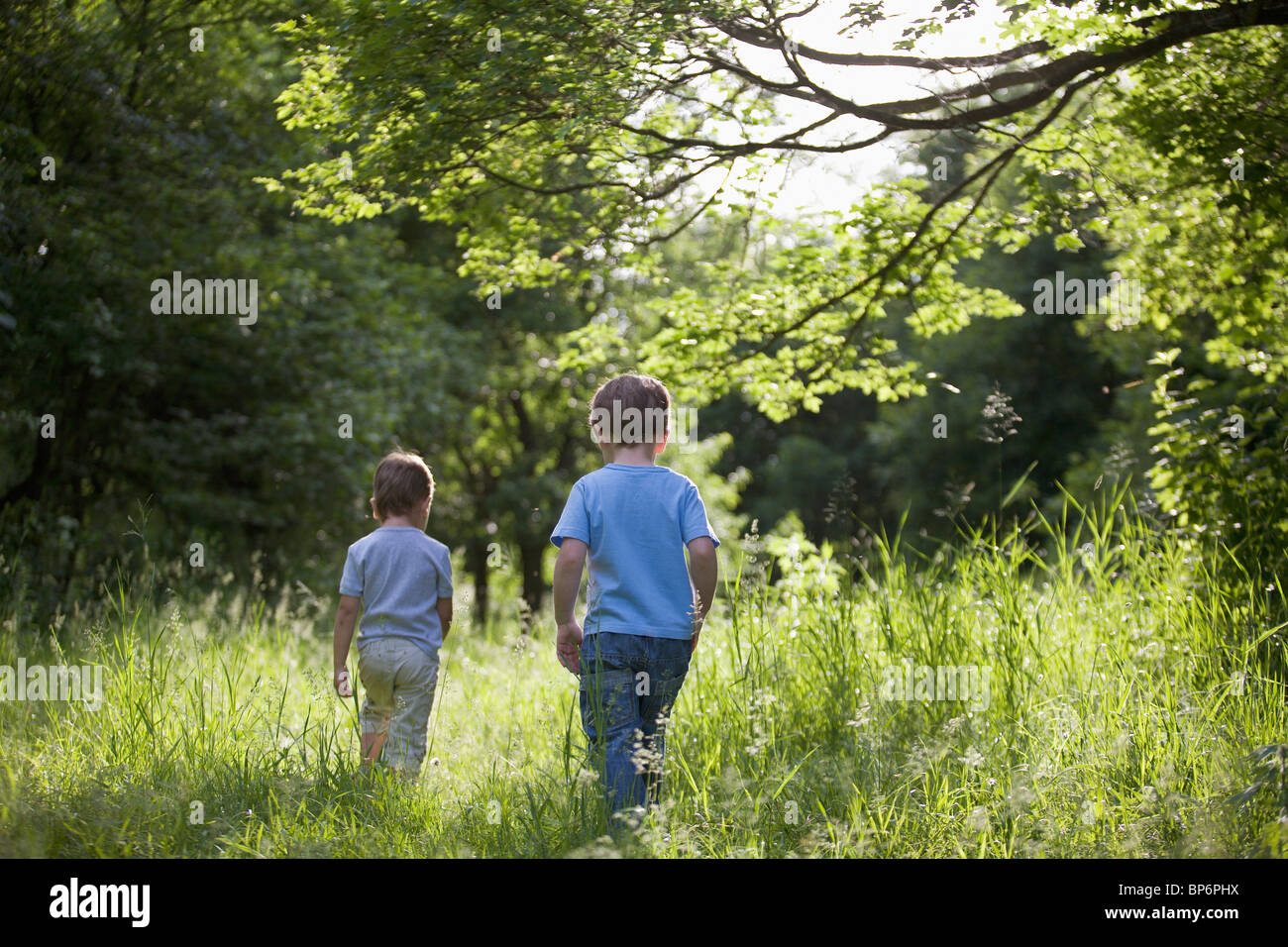 Two young boys walking outdoors in summer Stock Photo - Alamy