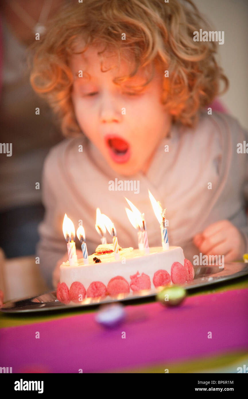 Boy blowing out candles on his birthday cake Stock Photo - Alamy