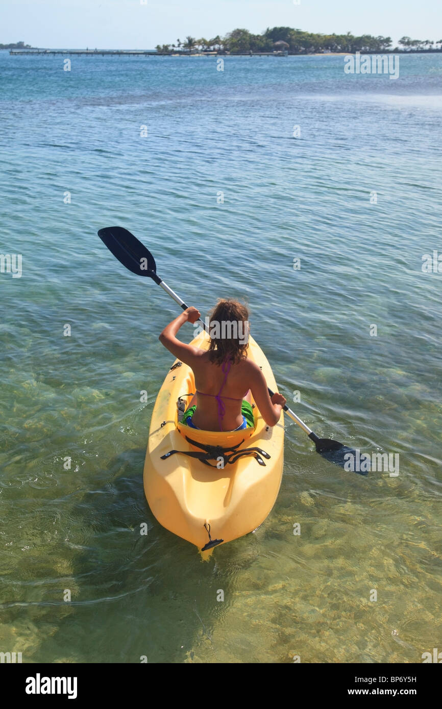 Roatan, Bay Islands, Honduras; A Young Woman Paddling A Kayak At ...