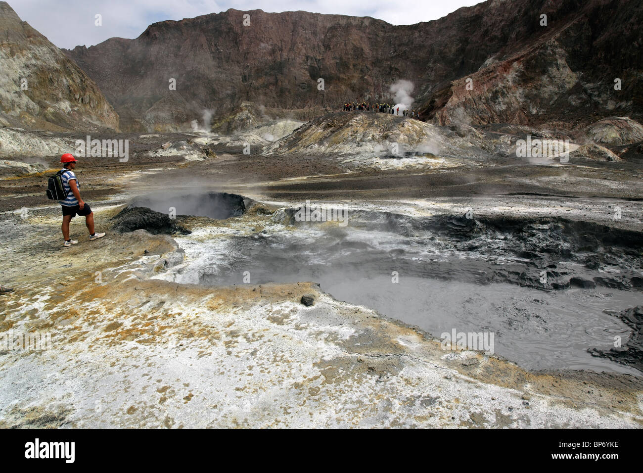 A tour guide looking over a bubbling volcanic mud pool on White Island ...