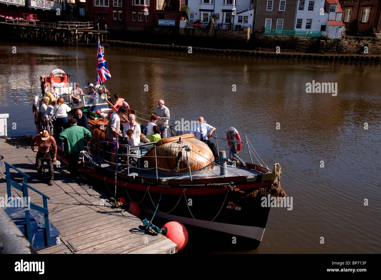 People getting on tourist boat docked in harbour, Whitby, North ...