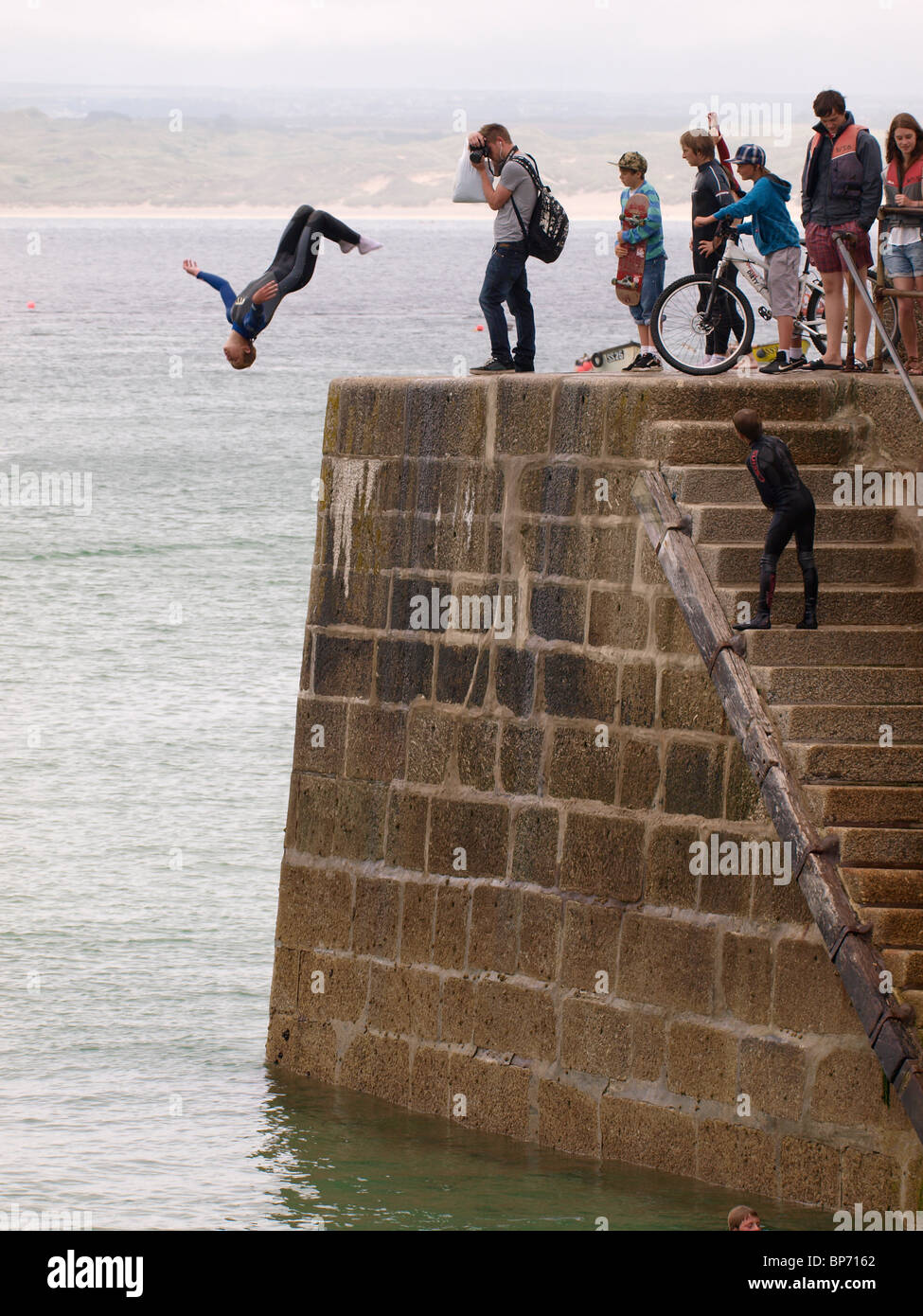 Young boy diving of the harbour wall at St. Ives, Cornwall Stock Photo ...