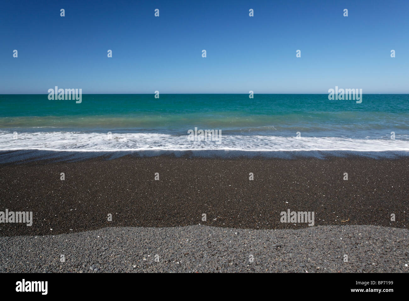 Sea lapping at the clean pebble beach in Napier on a bright day with ...