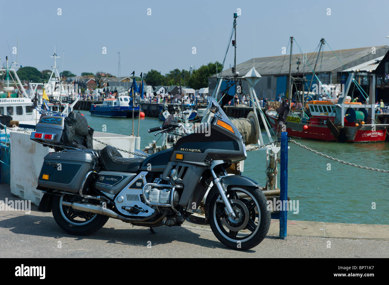 Motor Cycle parked at Whitstable Harbour ,Showing moored fishing boats ...