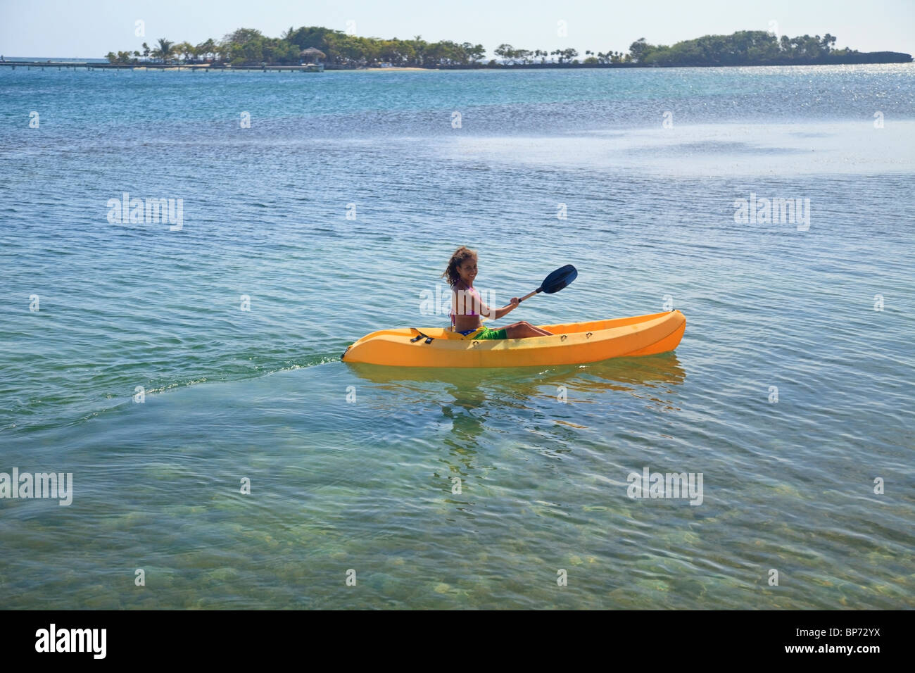 Roatan, Bay Islands, Honduras; A Young Woman Paddling A Kayak At ...