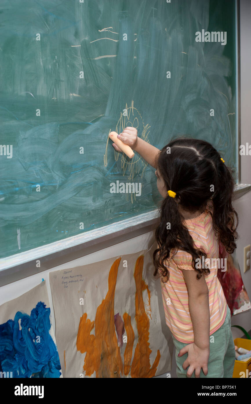 4 year old preschool girl writing on the blackboard at school Stock ...