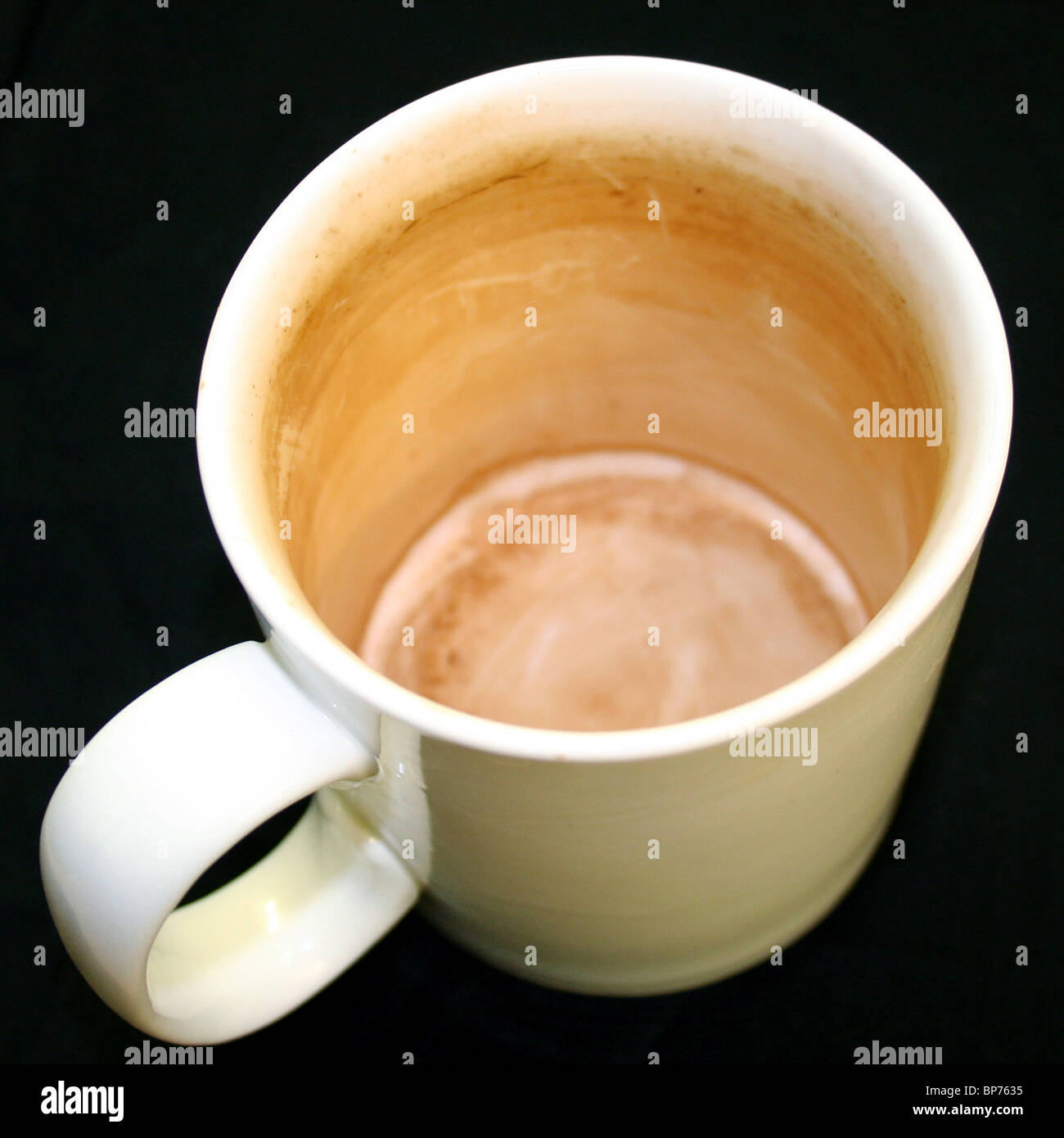 a dirty white tea mug on a black background Stock Photo - Alamy