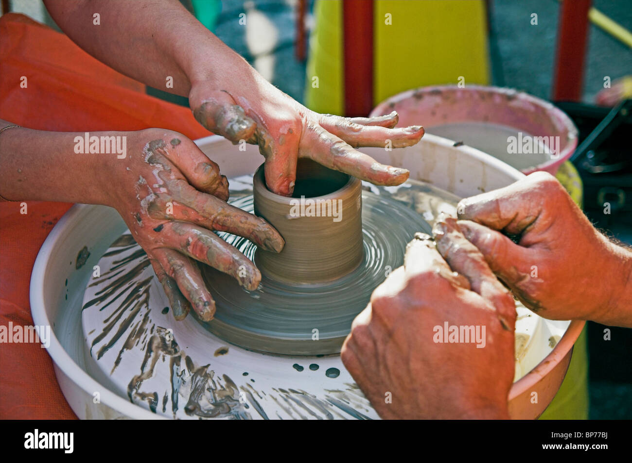 potter's hands guiding woman's hands to help her learn pottery Stock ...