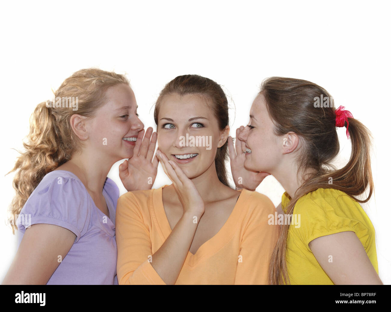 Friends telling secrets over white background Stock Photo - Alamy