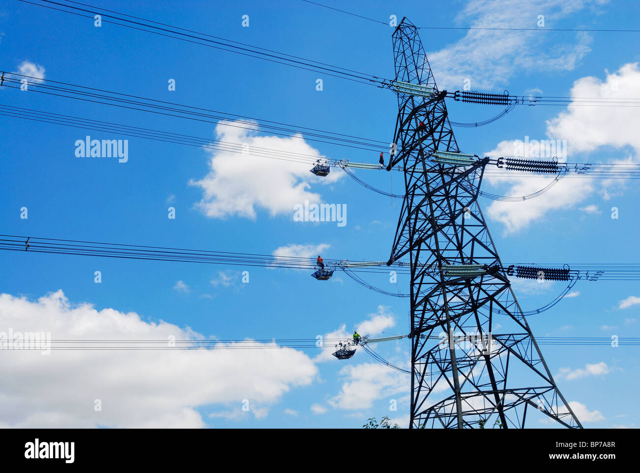 Electrical engineers carrying out maintenance on high voltage lines on ...