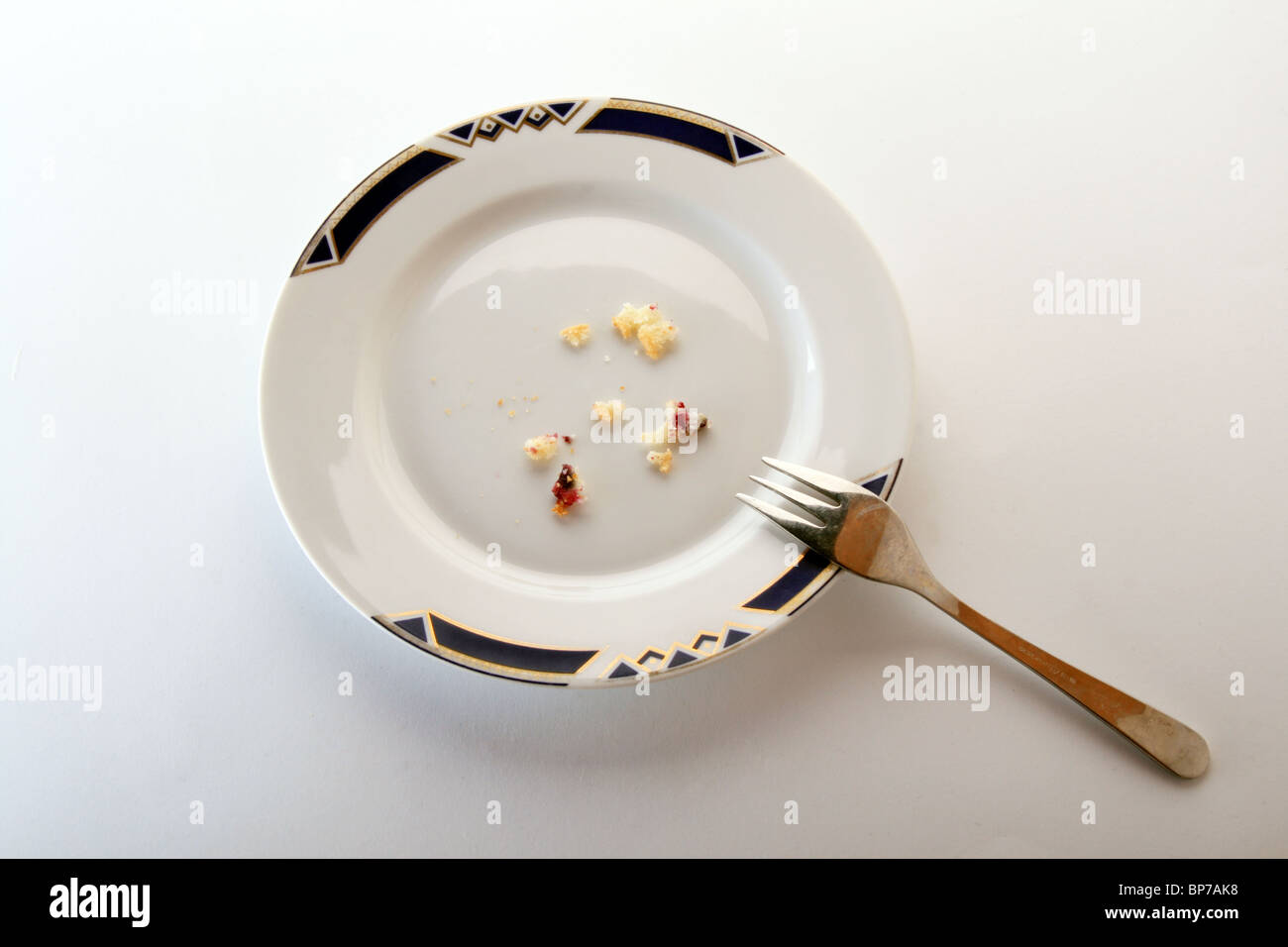 plate with crumbs. An arrangement of a white dessert plate with fork ...