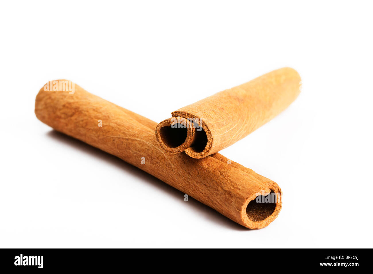 two brown cinnamon sticks in white background Stock Photo - Alamy