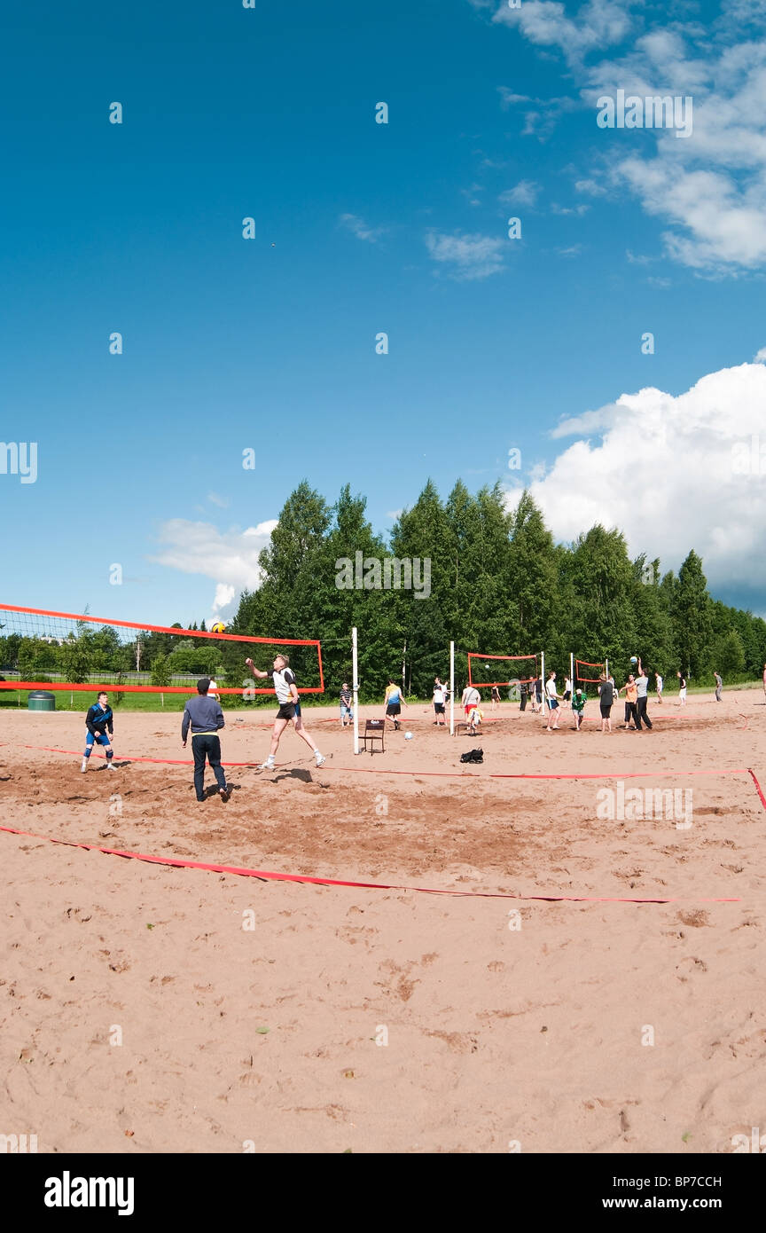 Volleyball ground on sand beach and sportsmen playing the game ...
