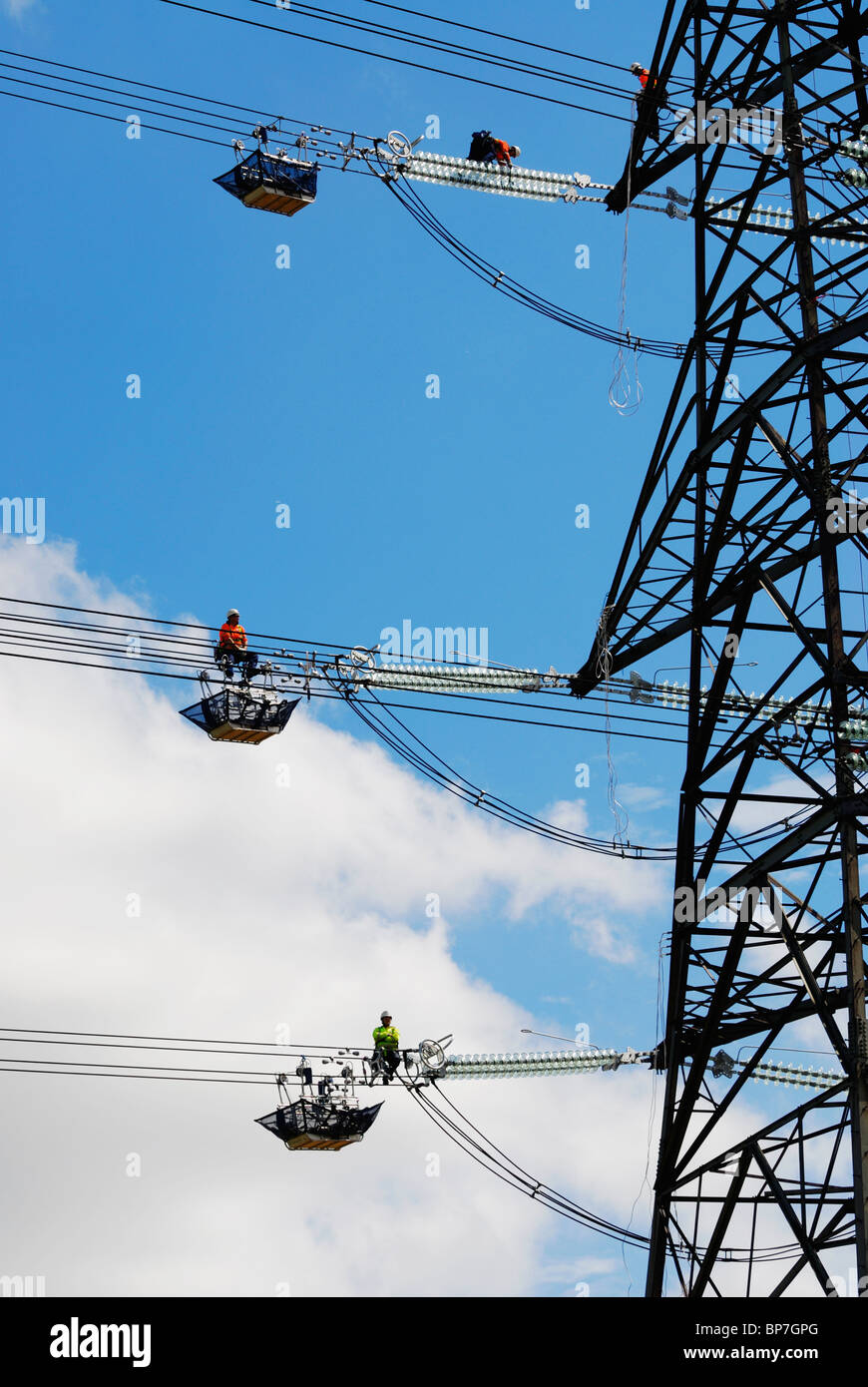 Electrical engineers carrying out maintenance on high voltage lines on ...