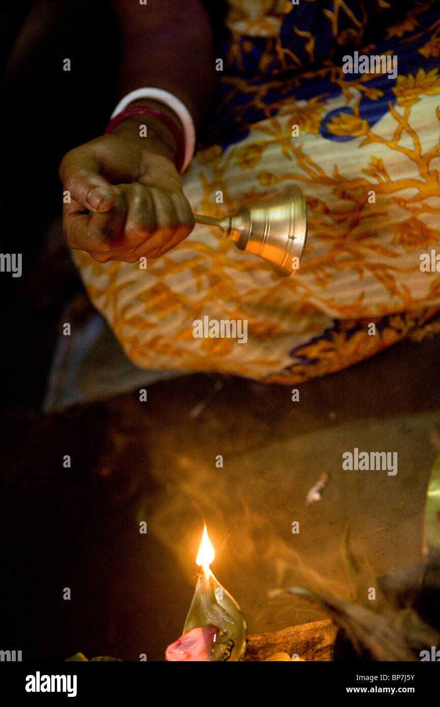 Islamic woman praying at a candle-lit shrine at home in Bangladesh ...