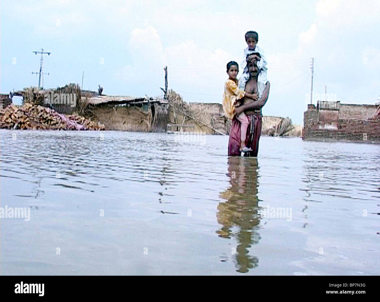 Man holds children passes through flooded road at flood hit area while ...