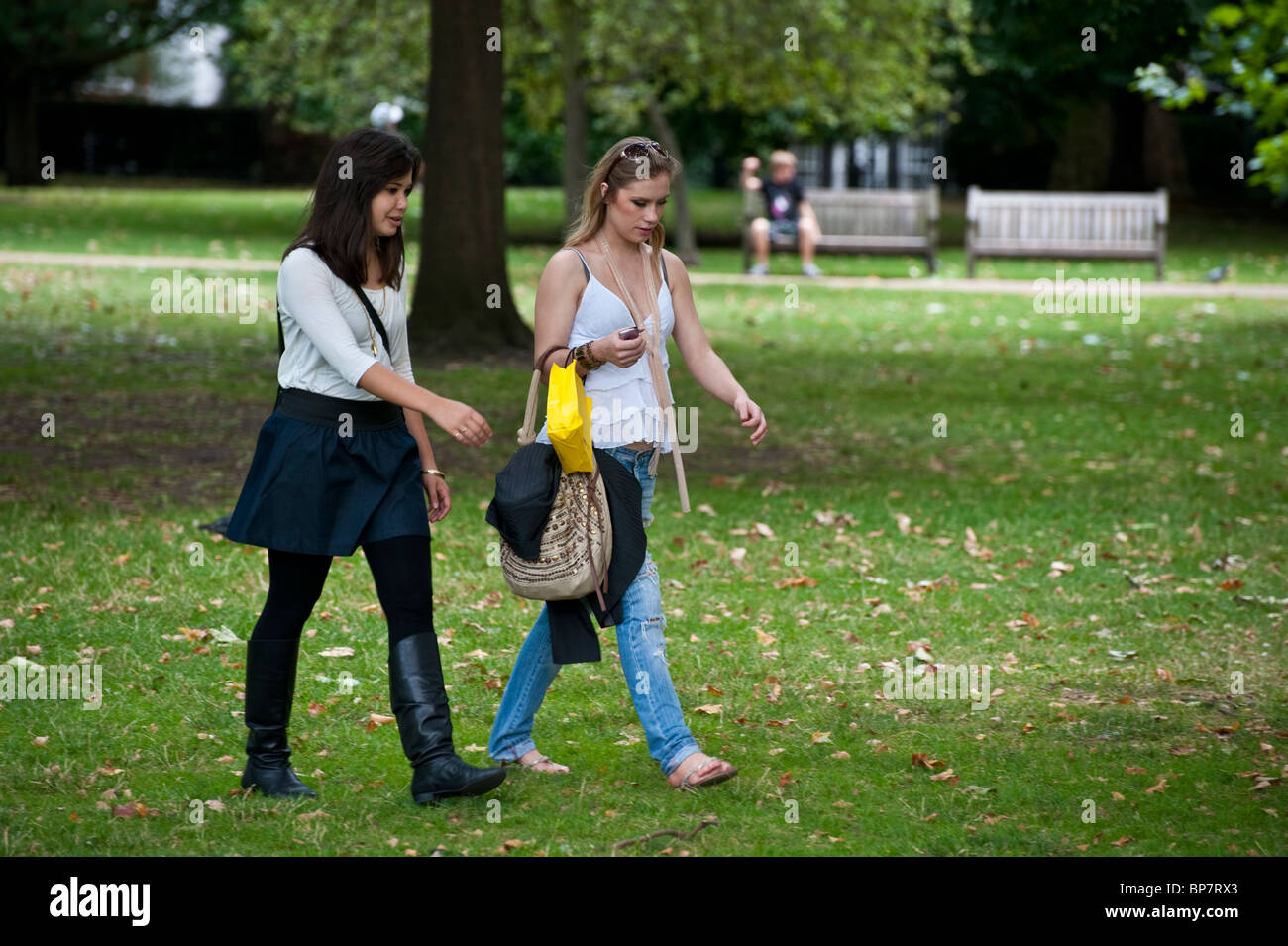 Two young women walking in a park Stock Photo - Alamy