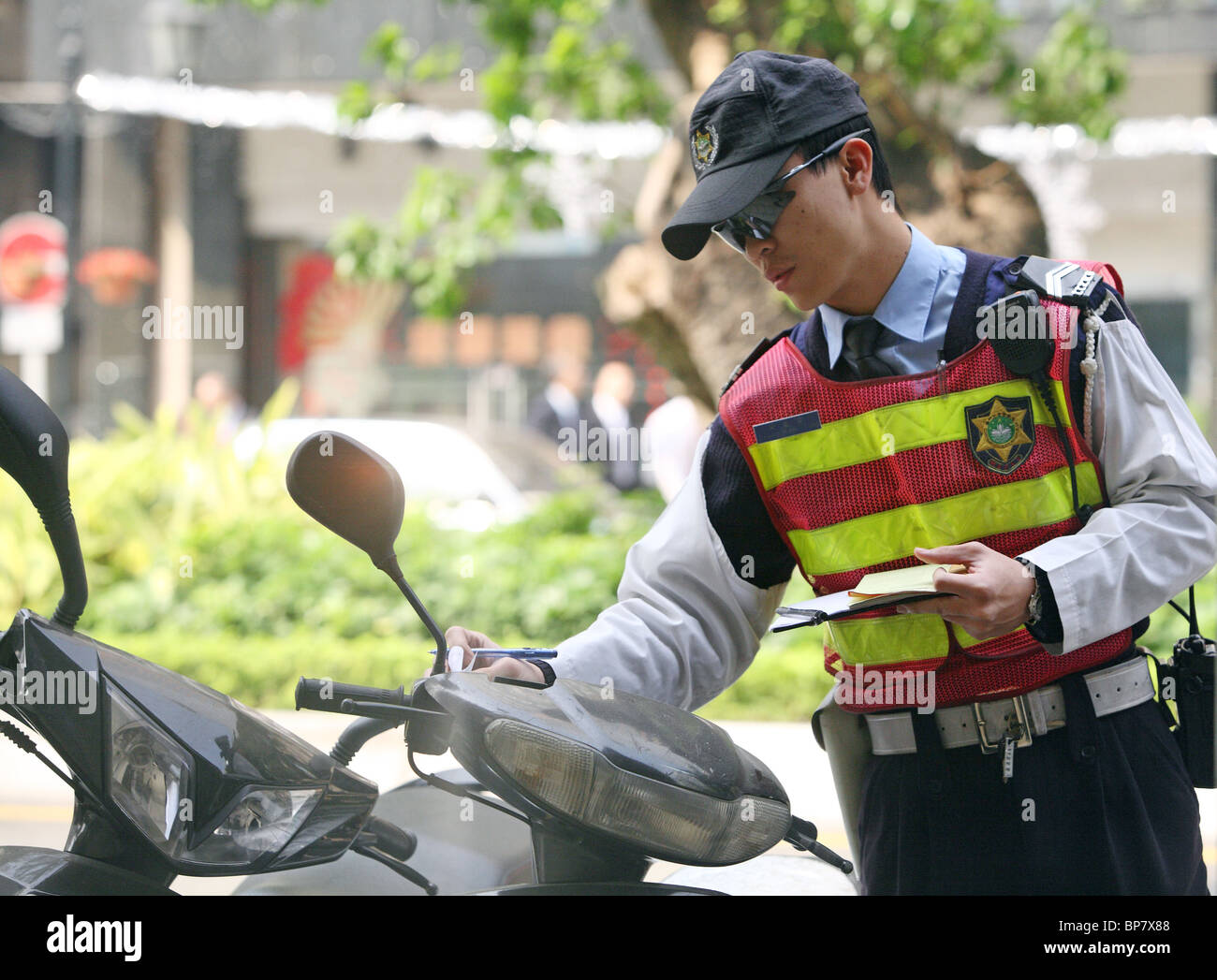 Policeman giving a parking ticket, Macao, China Stock Photo - Alamy