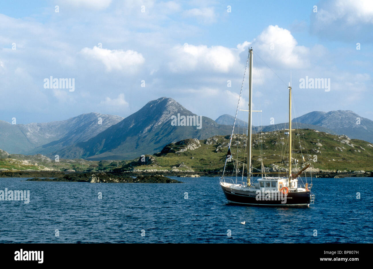 A sailing ketch near Letterfrack view towards the Twelve Bens mountains ...
