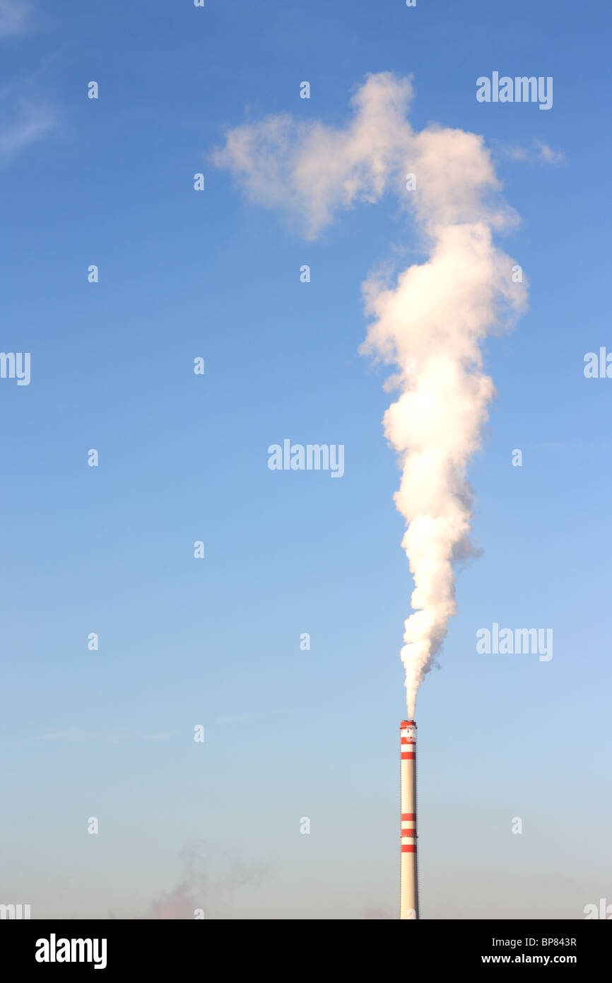 View of single chimney with fumes against blue sky Stock Photo - Alamy