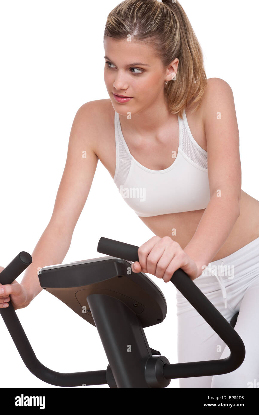 Fitness series - Young woman on exercise bike on white background Stock ...