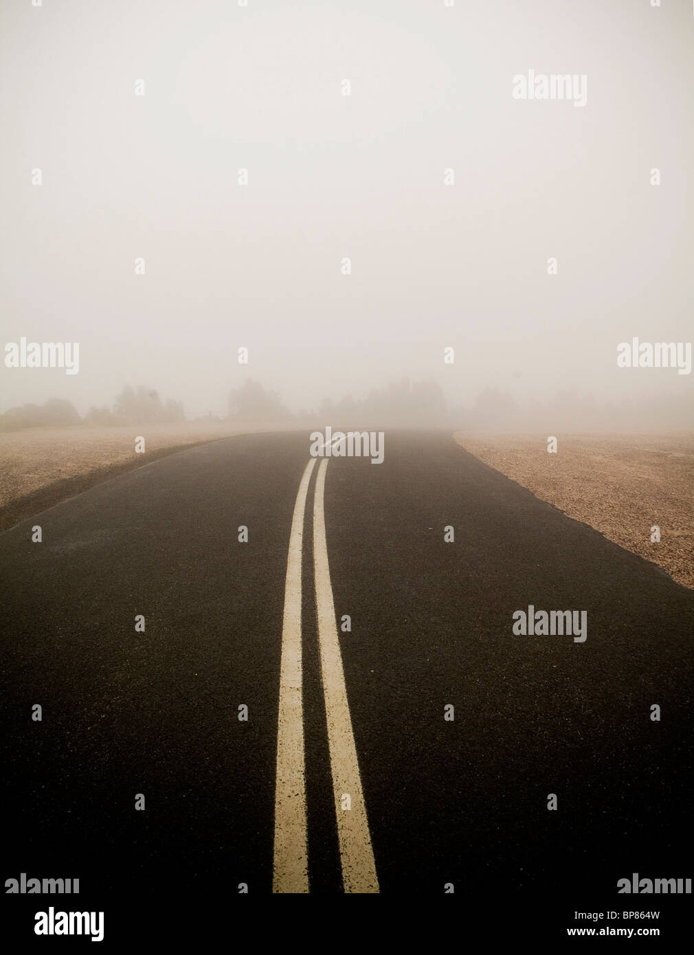 Dark road with double lines disappears into very thick fog Stock Photo ...