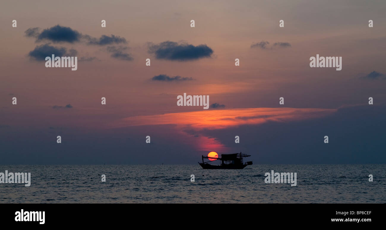 Fishing boat in sunset sky Stock Photo - Alamy