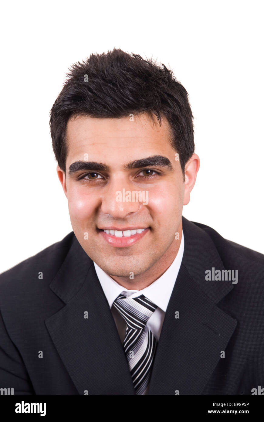 Portrait of a young Middle Eastern business man smiling against a white ...