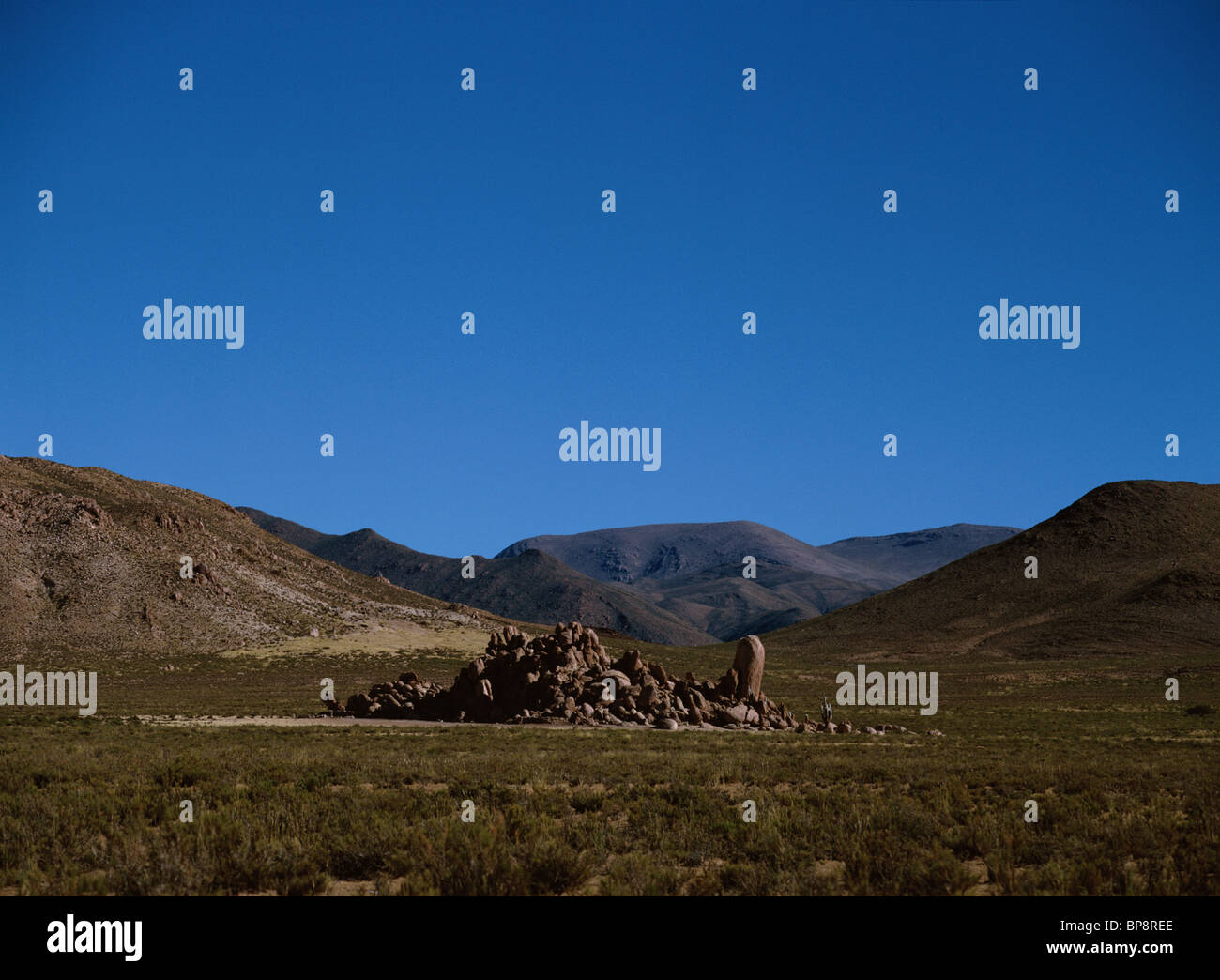 A Small Heap of Rocks With Mountains in the Distance and Blue Sky Above ...