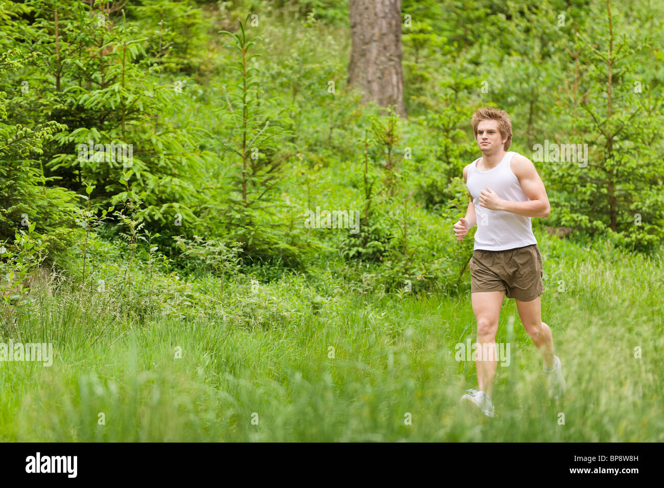 Morning run: Young man jogging in nature in sportive outfit Stock Photo ...
