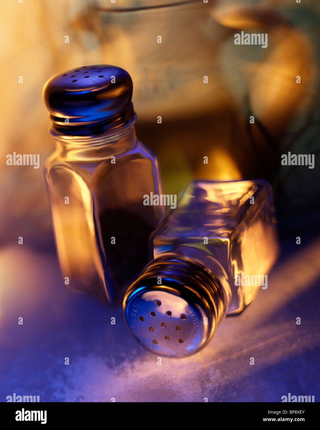 Glass Salt and Pepper shakers in golden light, using selective focus ...