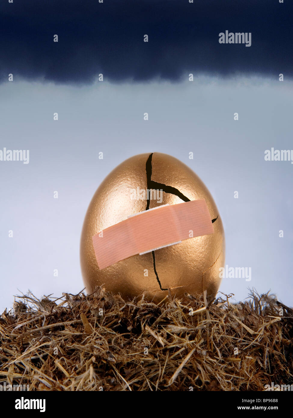 A nest egg cracked with a band-aid as a metaphor for reduced values of ...