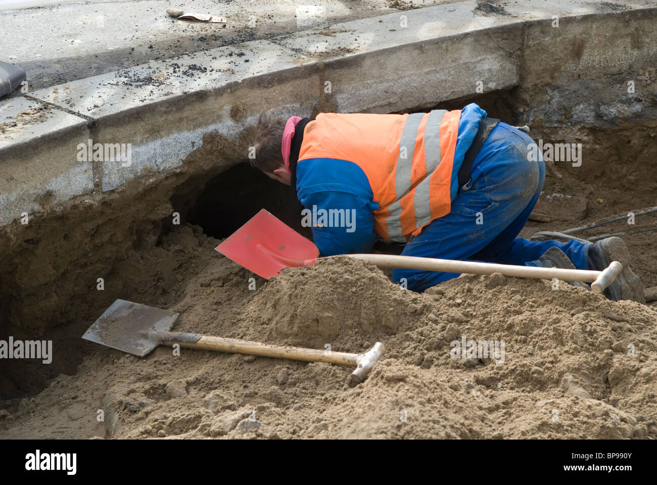 Construction worker in overall digging in road construction Stock Photo ...