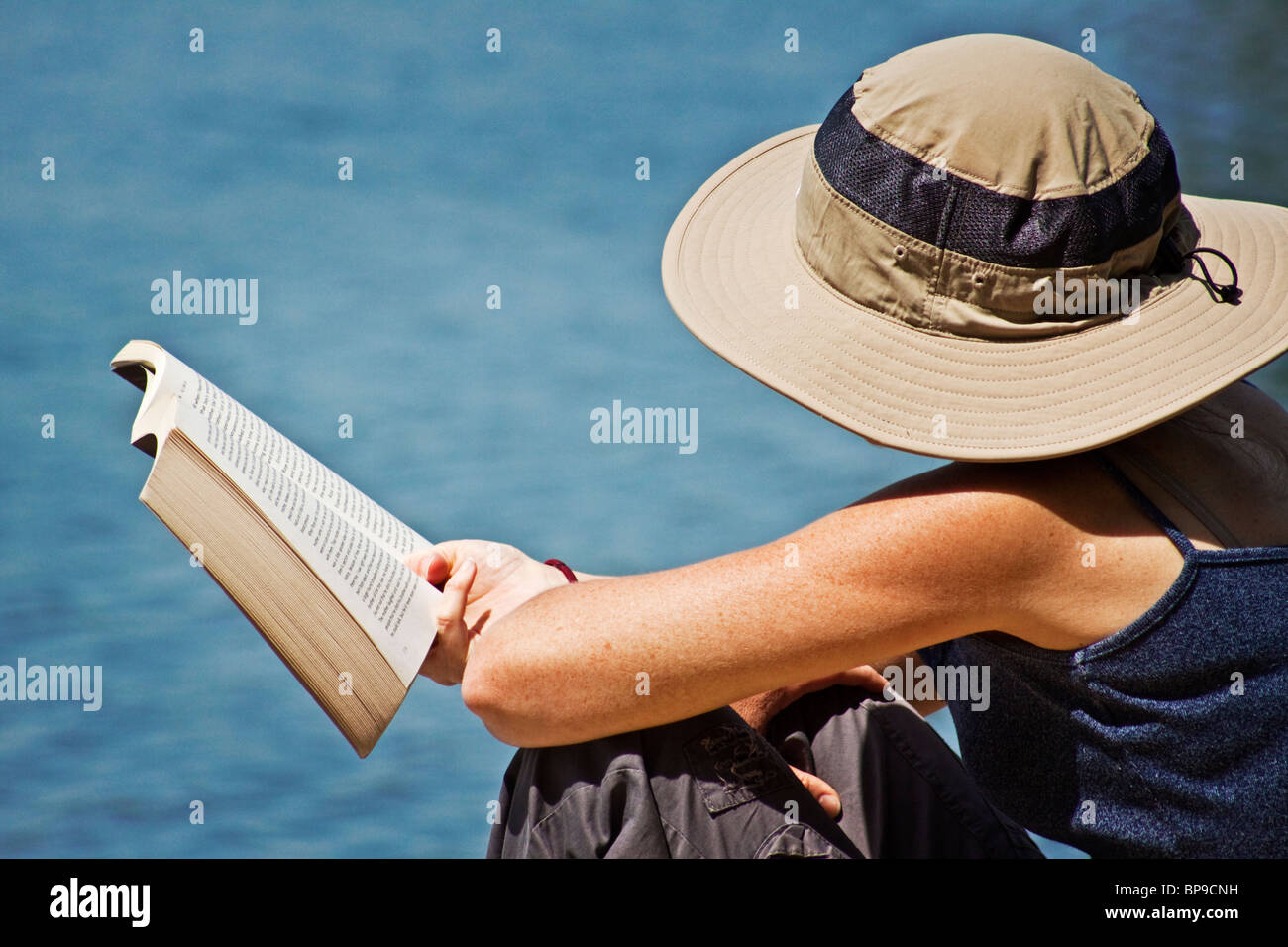 woman reading a book by a lake Stock Photo - Alamy