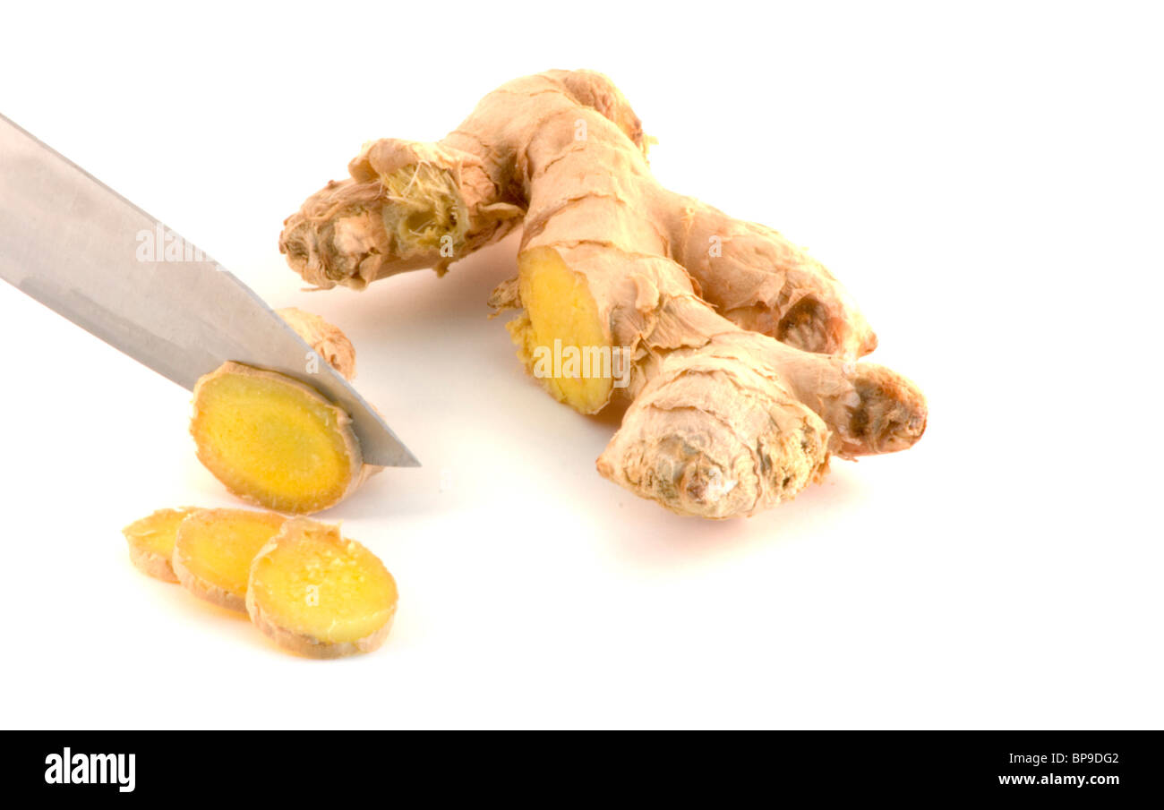 Cutting ginger with knife over white background Stock Photo - Alamy