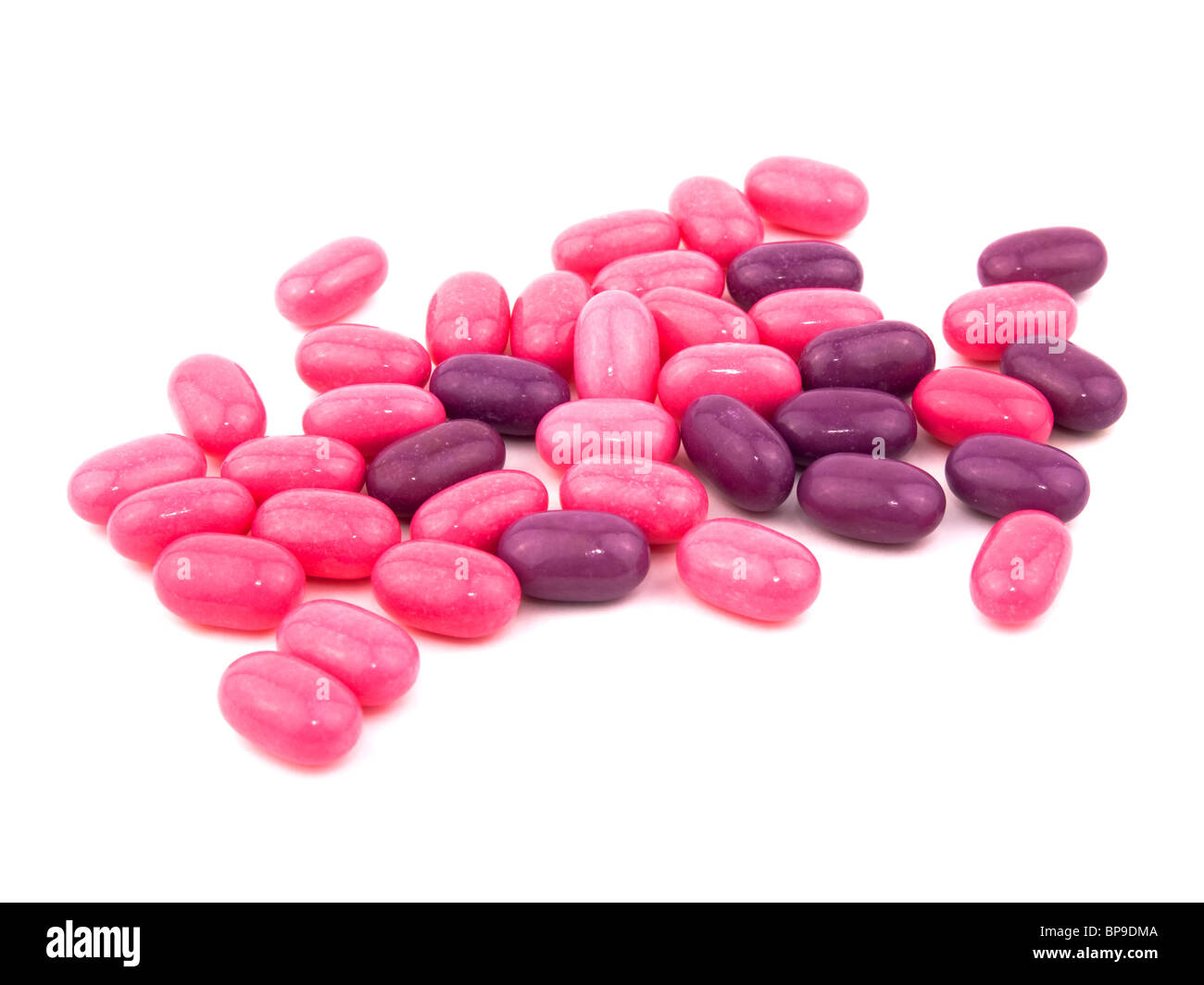 Pink and purple candies on white background Stock Photo - Alamy