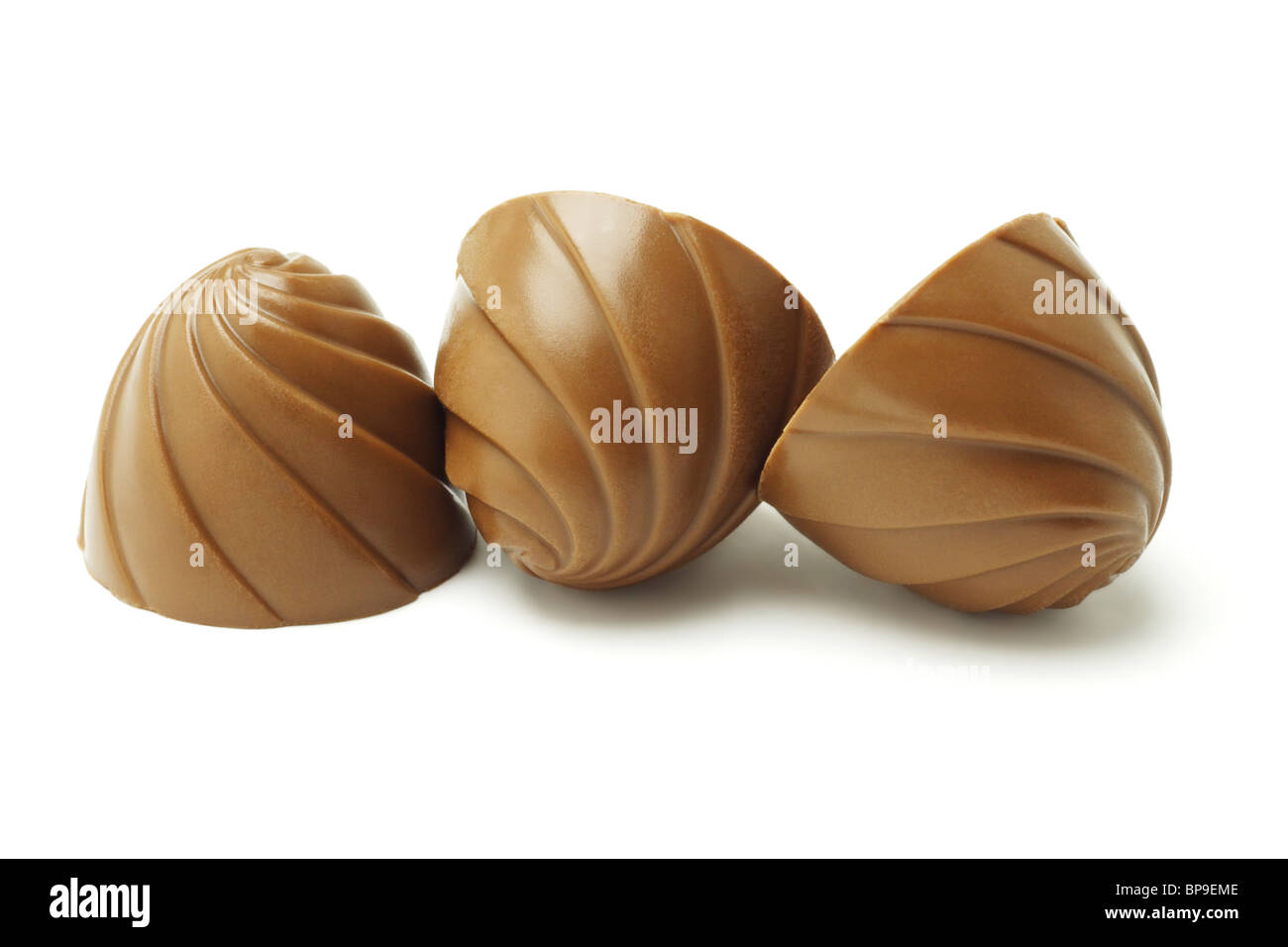 Three chocolate candies in a row on white background Stock Photo - Alamy