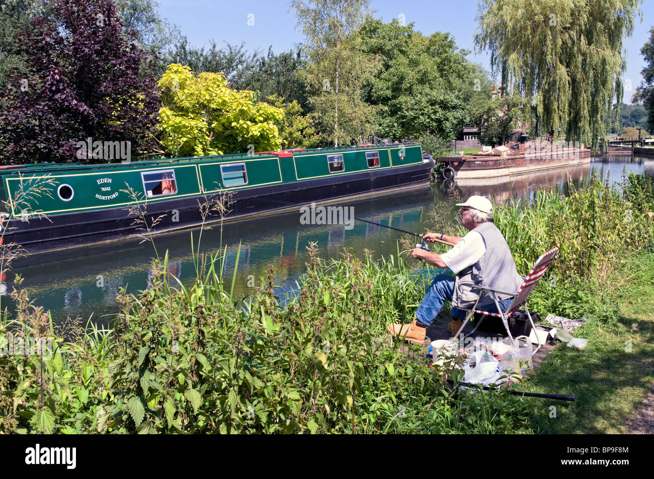 Man fishing by the bank of the River Lee Navigation canal ...