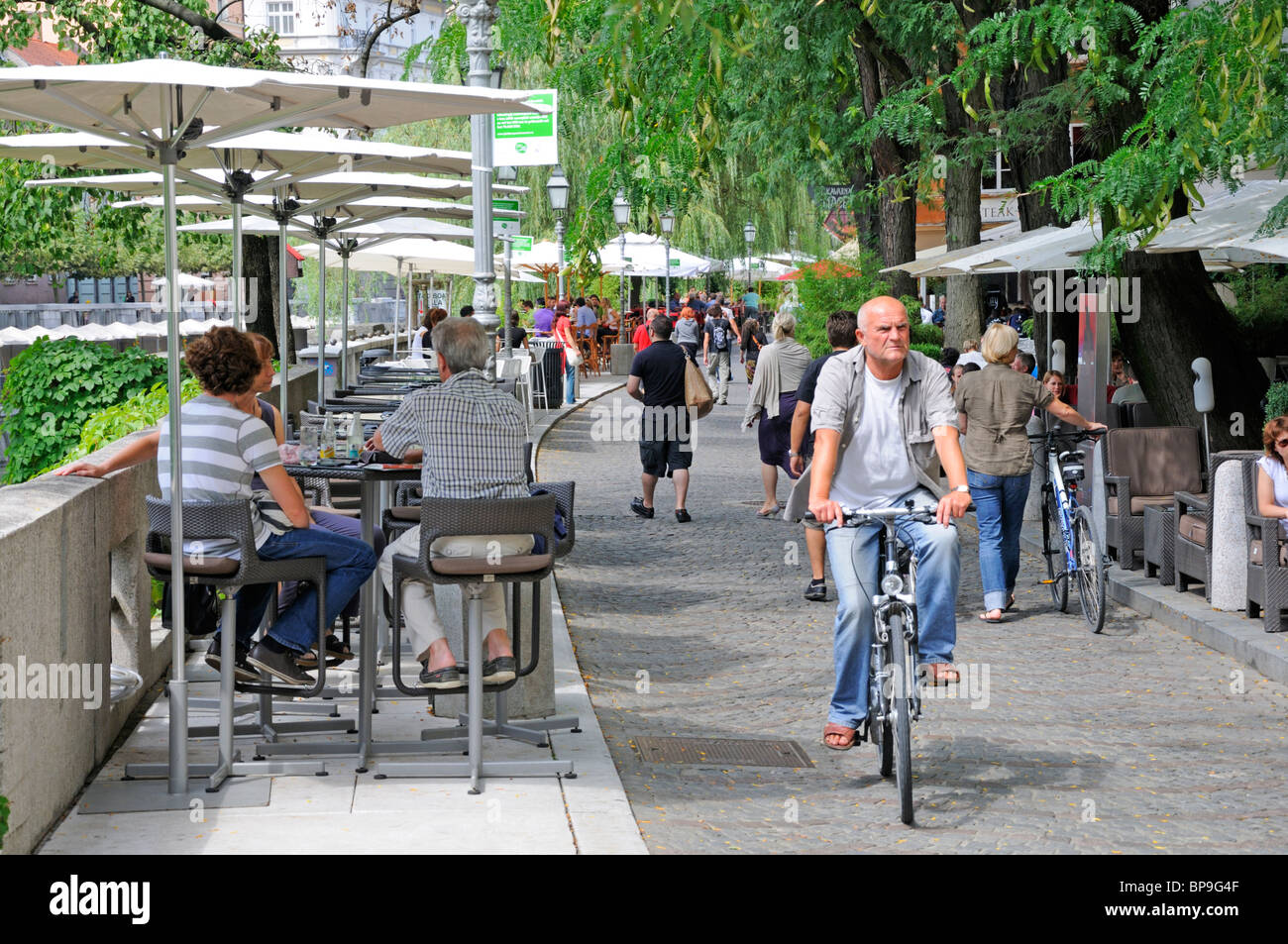 Ljubljana, Slovenia. Cankarjevo nabrezje (embankment) Cafe tables and ...
