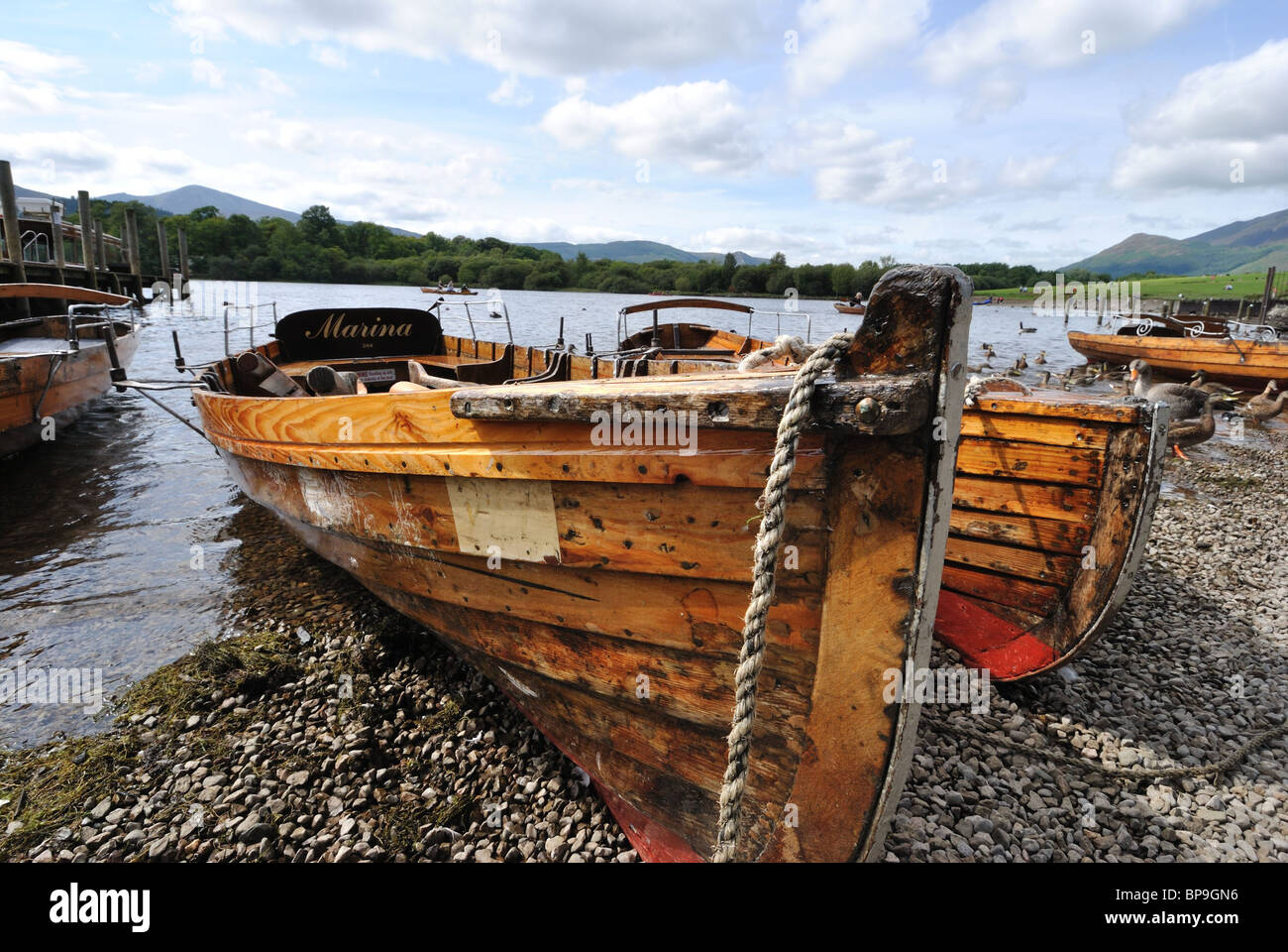 An old wooden rowing boat on the shore of Derwent Water in the Lake ...