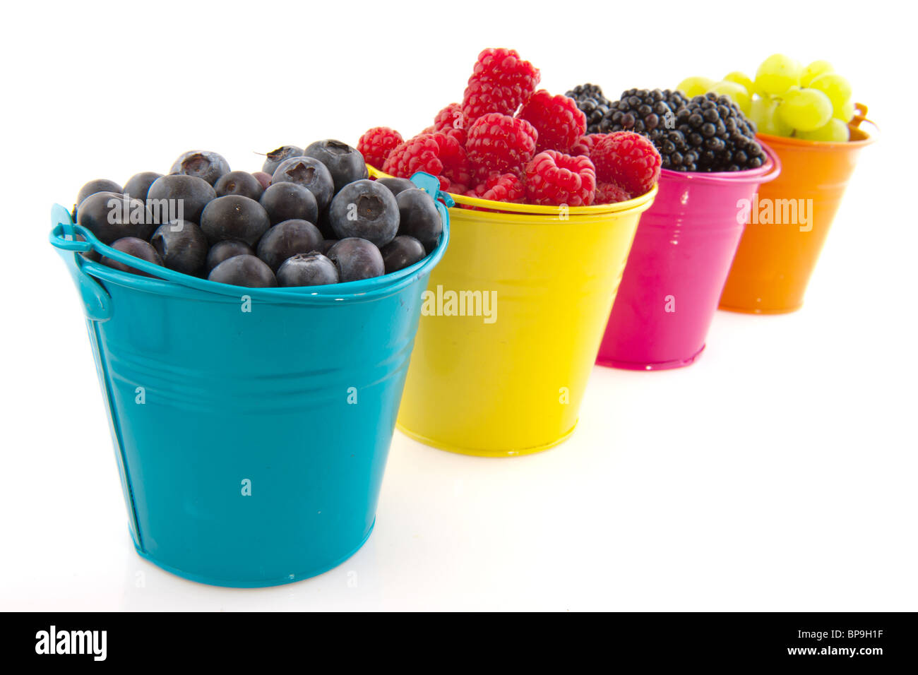 colorful buckets with fresh summer fruit isolated over white Stock ...