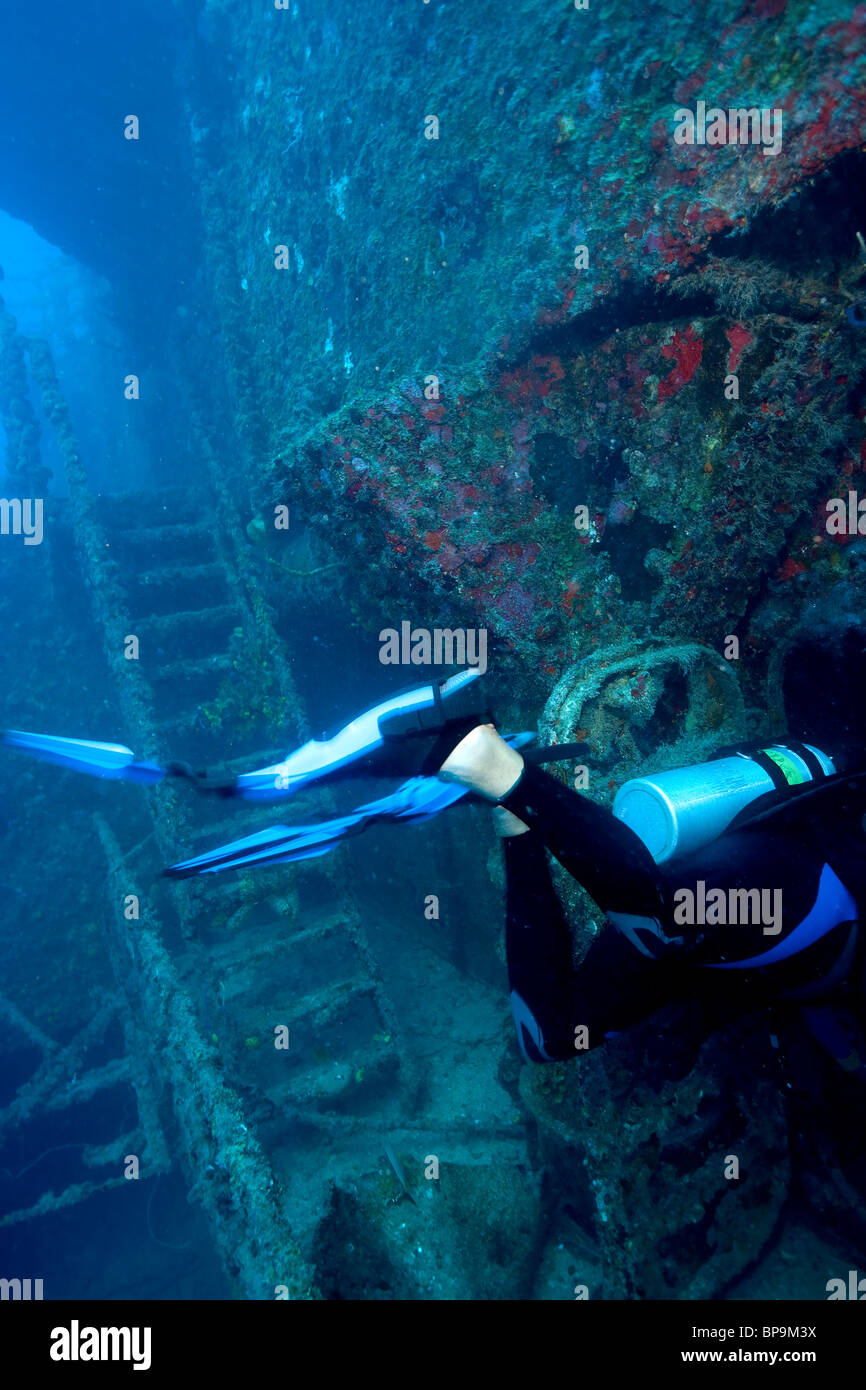 Diver disappears inside an interior passageway on a deep shipwreck ...