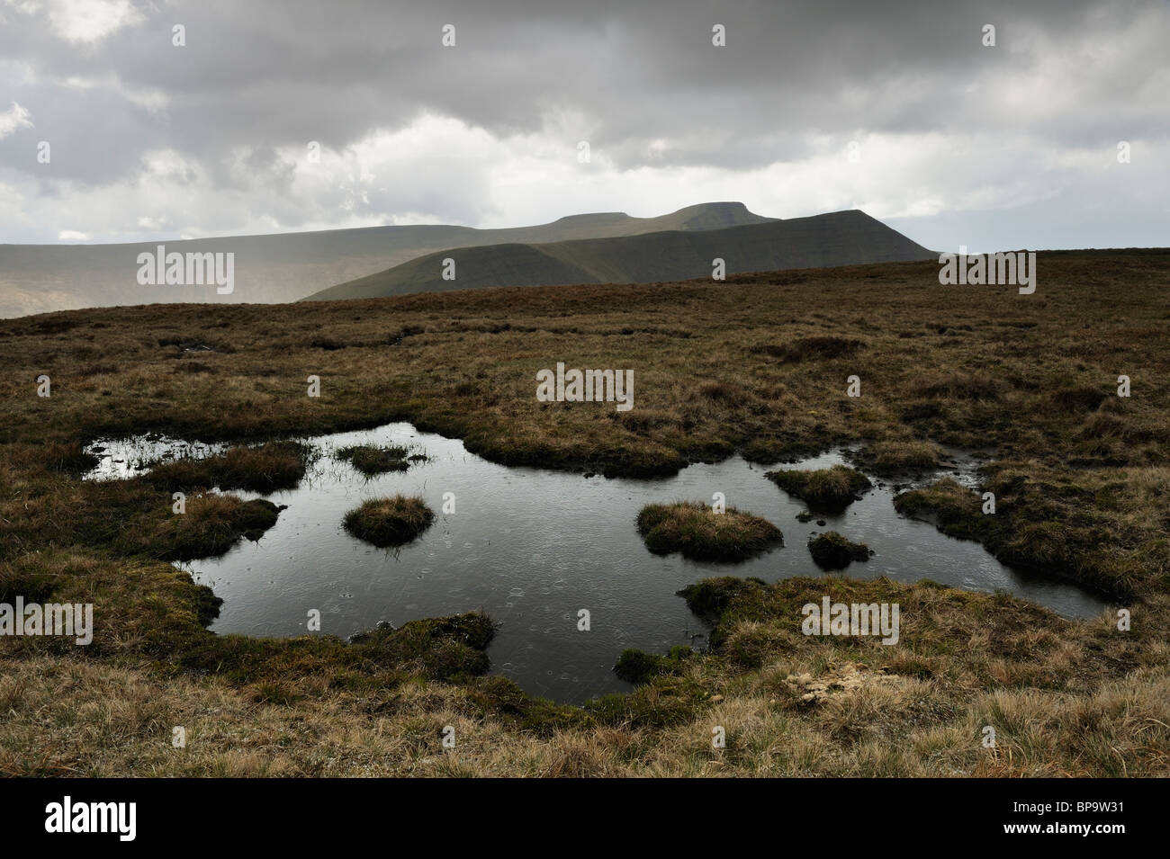 A puddle atop the Brecon Beacons, Wales on a rainy day. The peaks of ...