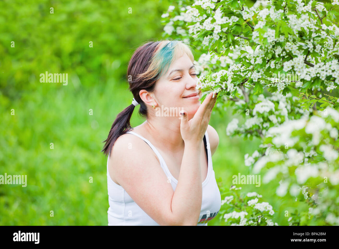 Beautiful young woman smelling flowers from a tree in spring Stock ...