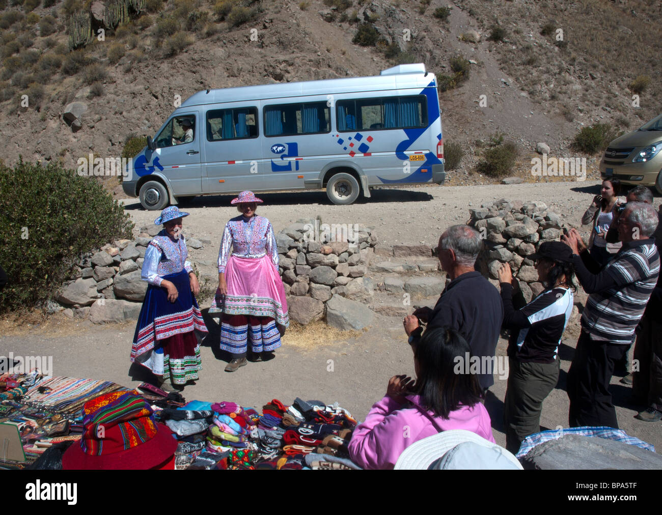 Western tourists wear local costumes at a lookout point in the Colca ...