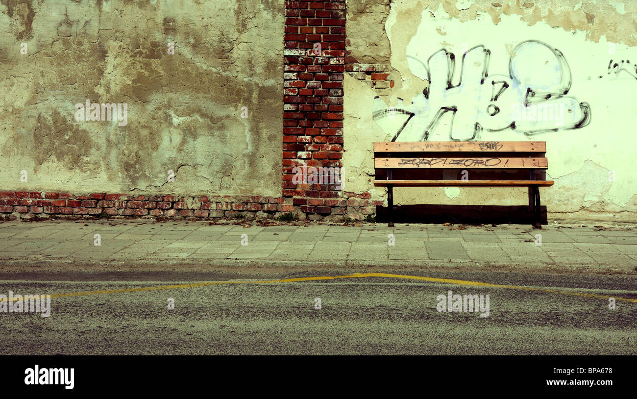 Bench in front of rusty wall Stock Photo - Alamy